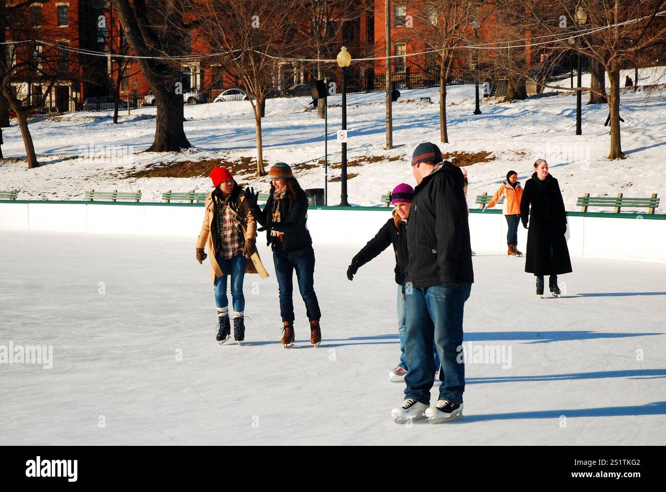 People enjoy winter activities by ice skating on a rink in the Frog ...