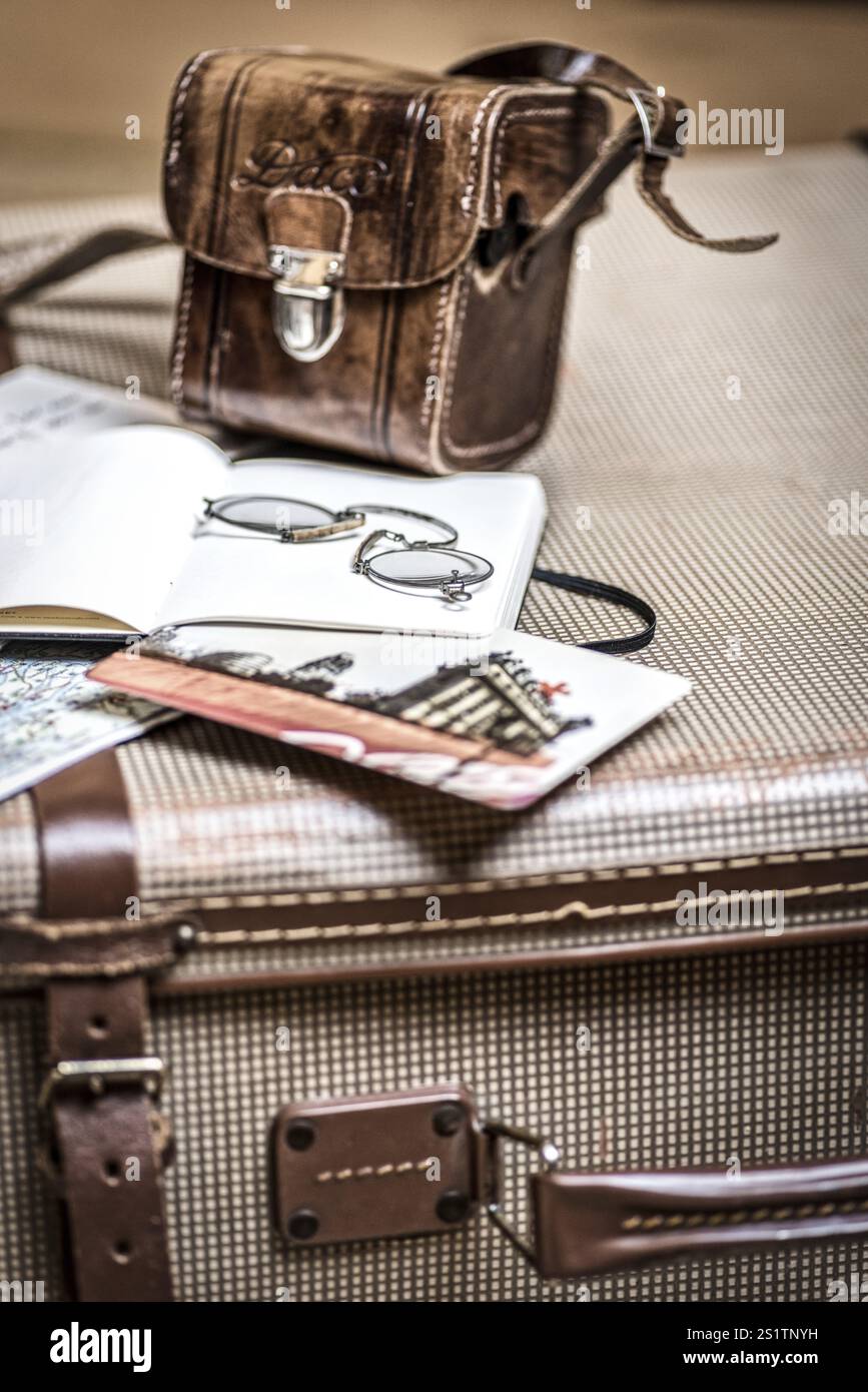 Still life with an old camera, suitcase, glasses and a road map in ...