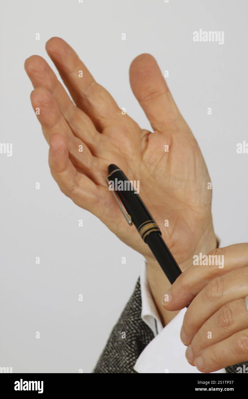 Woman's hand holding a biro Stock Photo - Alamy