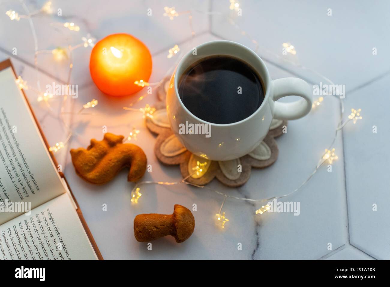 Cozy morning scene with cup of coffee, burning candle, an open book ...
