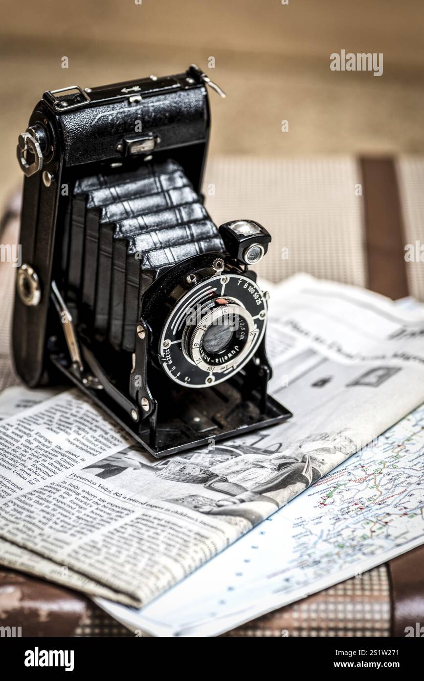 Still life with an old camera, newspaper and a road map in vintage ...