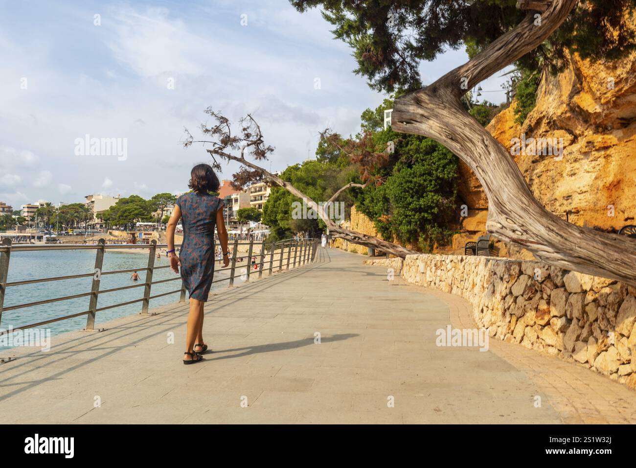 Tourist walking on a seaside promenade in puerto cristo, enjoying the ...