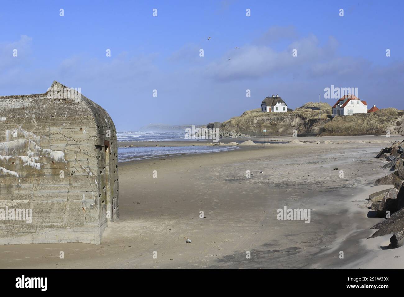 Beach with crashed bunkers of the German Wehrmacht and houses on the ...