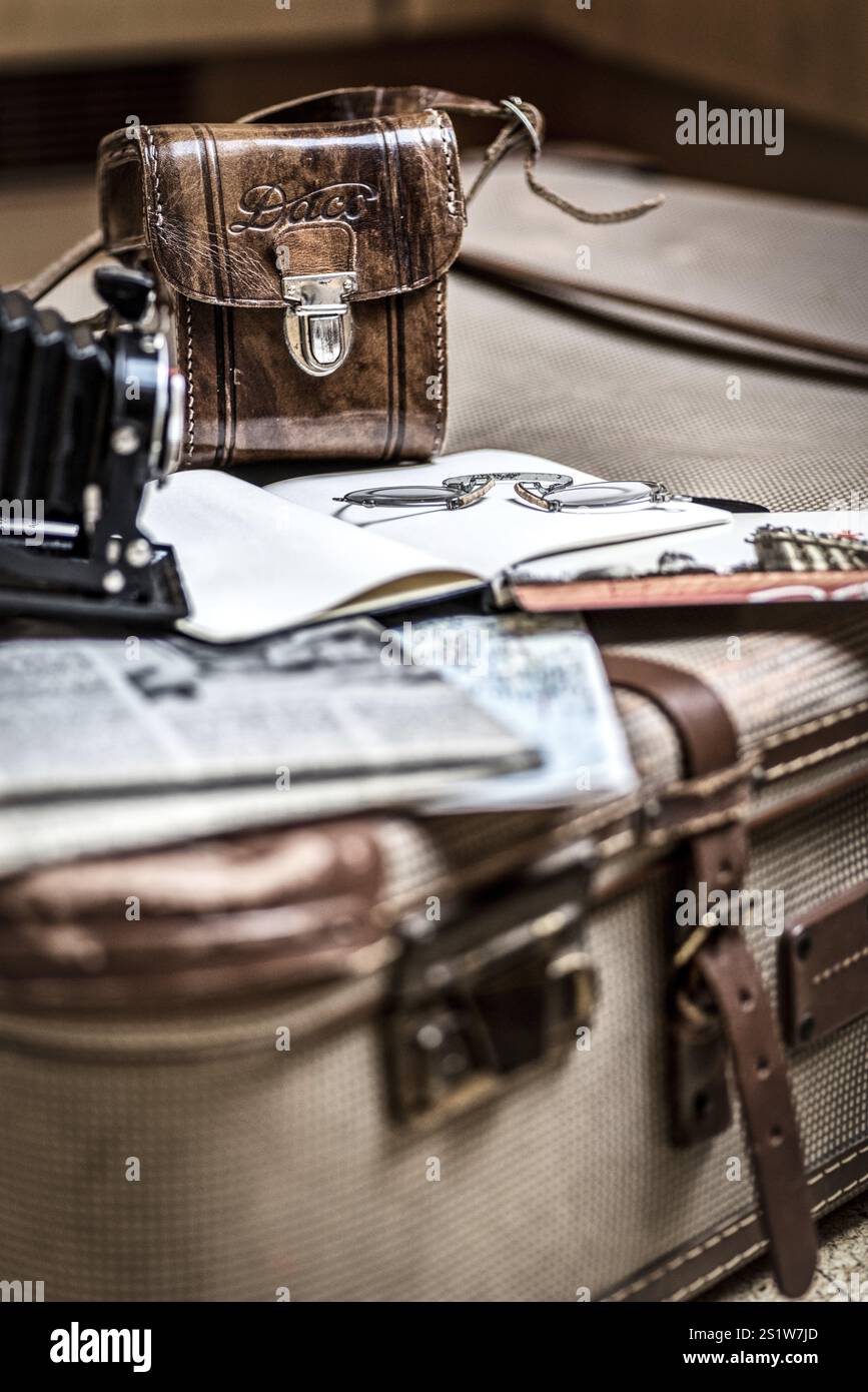 Still life with an old camera, suitcase, glasses and a road map in ...