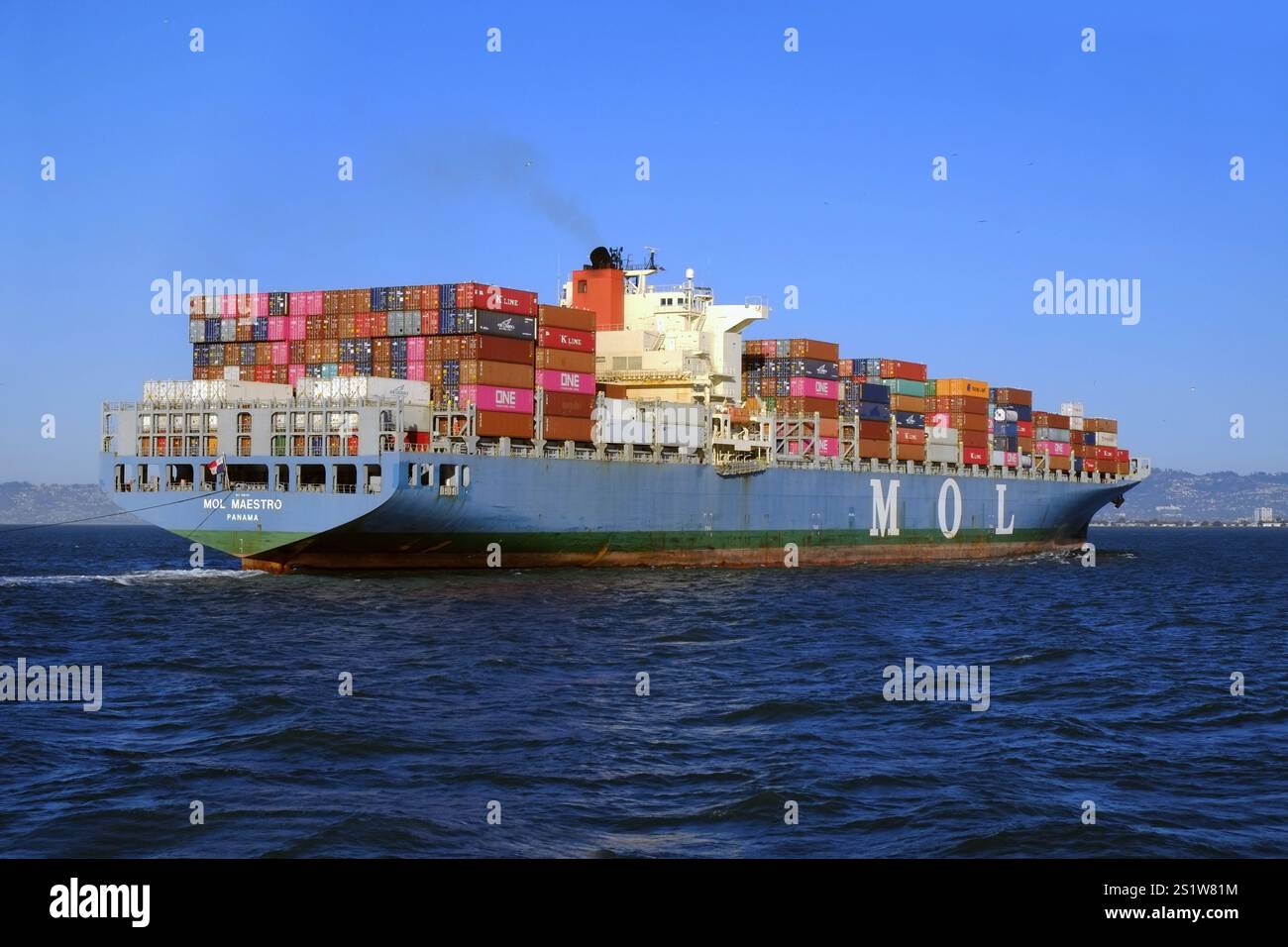 A heavily laden container ship enters San Francisco Bay in sunny ...