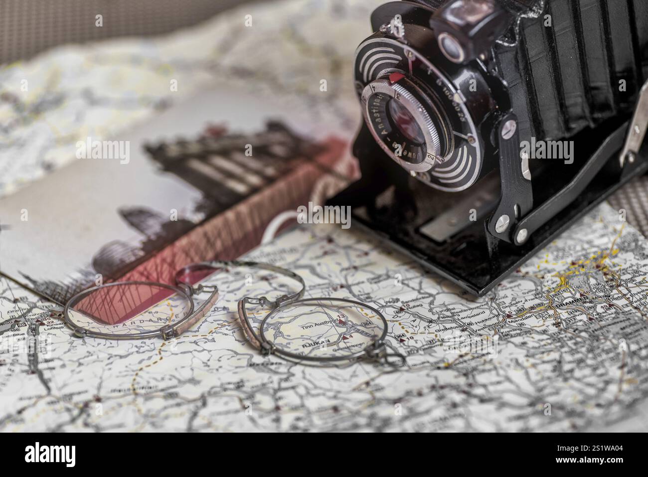 Still life with an old camera, glasses and a road map in vintage style ...