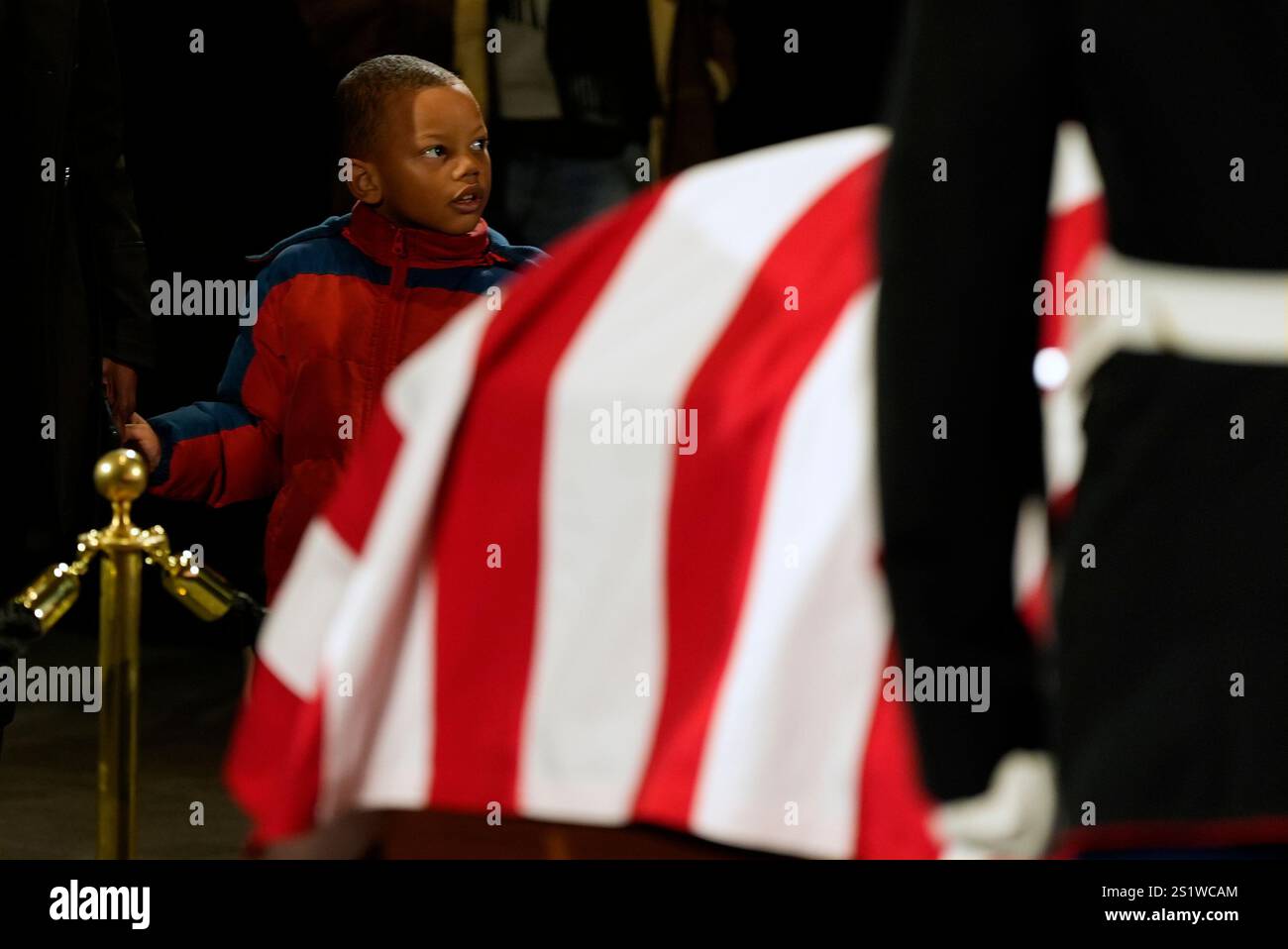 A child pauses as mourners view the casket of former President Jimmy ...