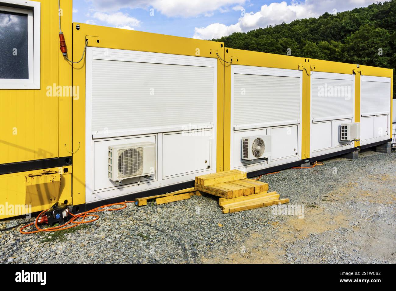 White air conditioning unit on the back side of bright yellow coloured ...