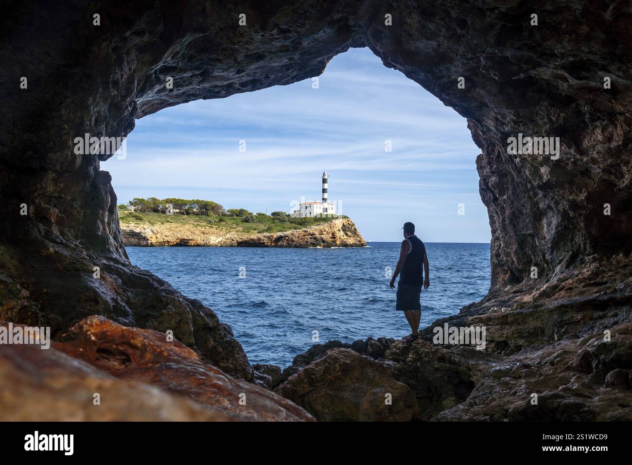 Tourist stands inside the arc natural cave in portocolom, mallorca ...
