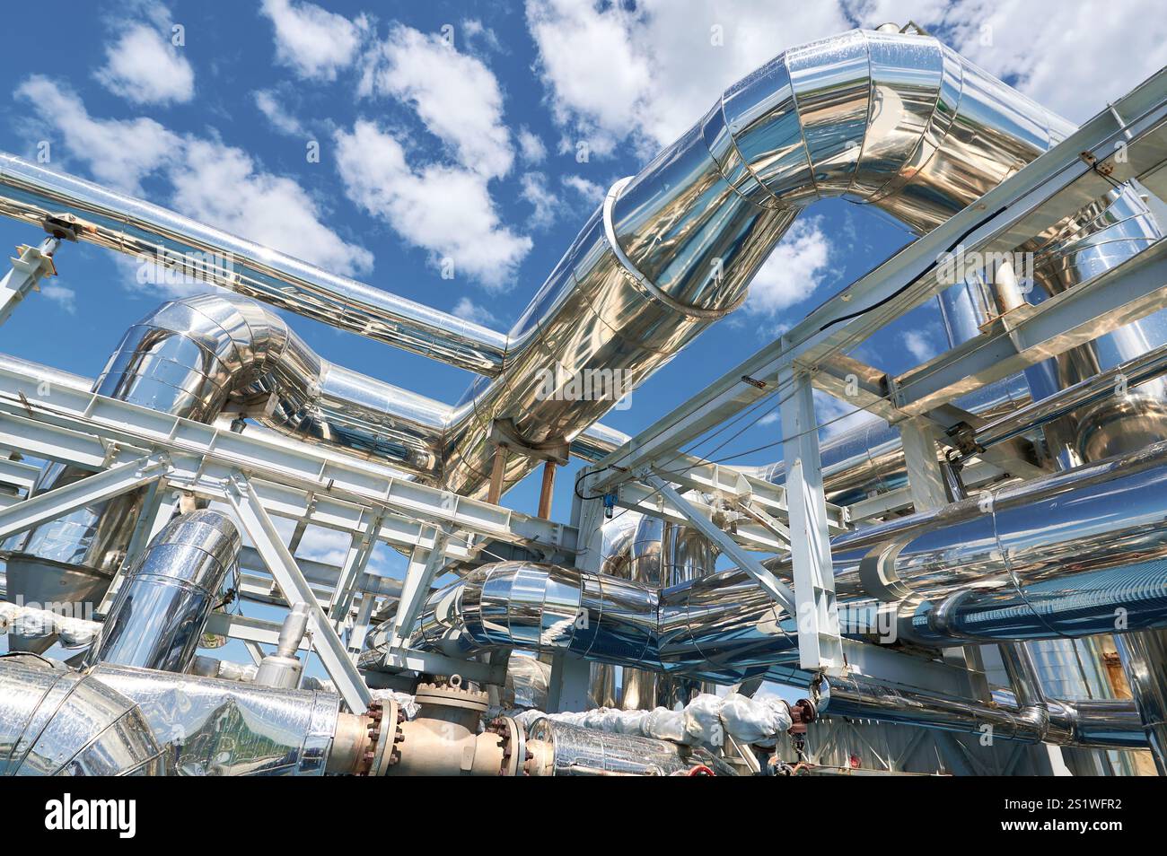 Pipelines weave through a chemical plant under a clear blue sky ...