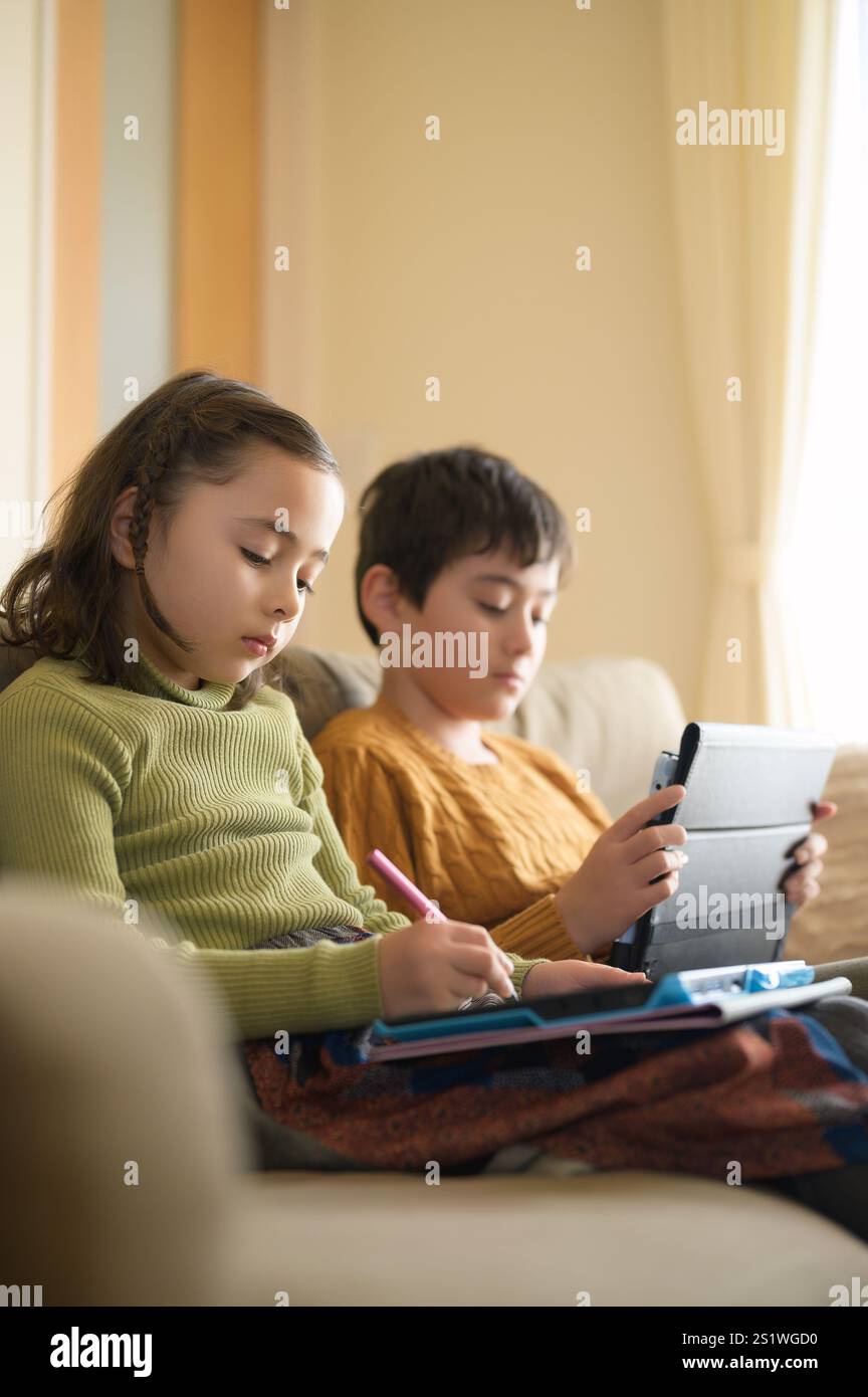Two Kids Studying at Home with a Tablet Stock Photo - Alamy
