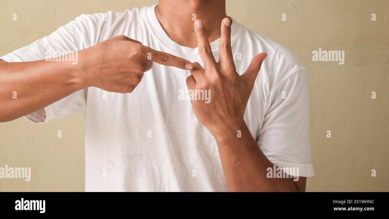 Young man raising hands while talking on sign language, showing word ...