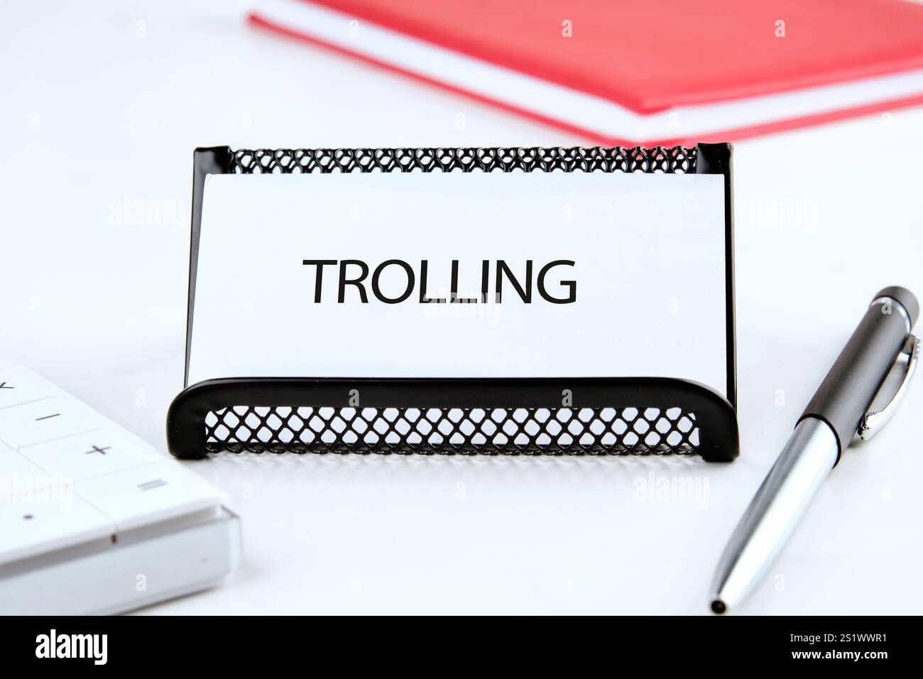 A business card displaying the word trolling is placed in a black ... A business card displaying the word trolling is placed in a black ...