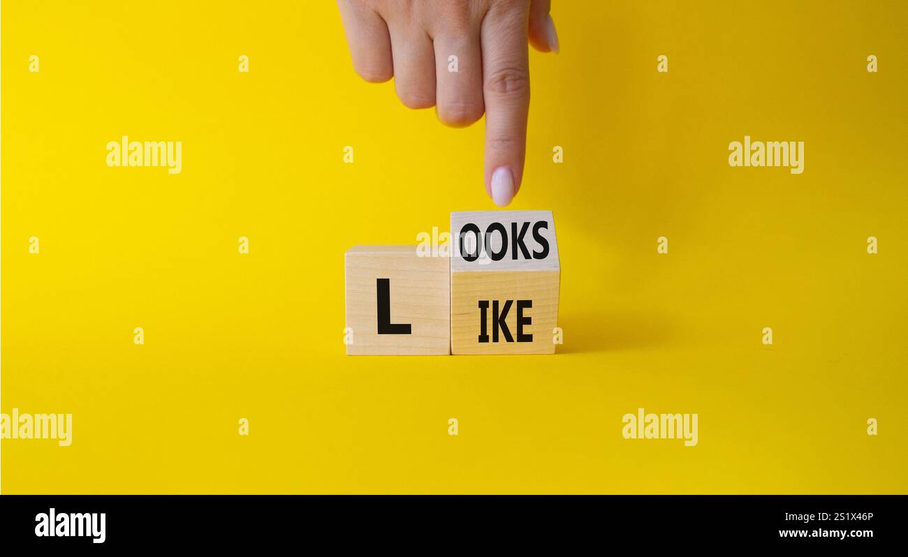 Looks like symbol. Businessman hand points at turned wooden cubes with ...