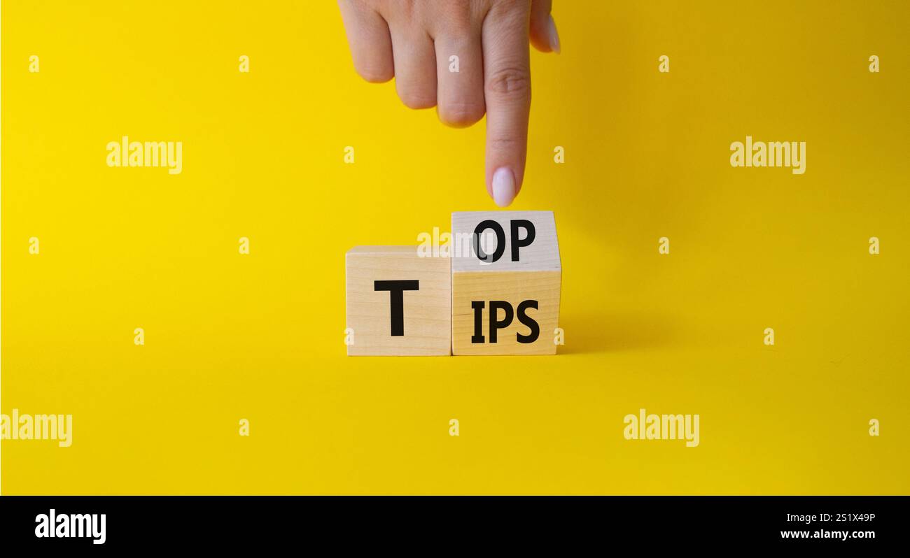 Top Tips symbol. Businessman hand points at turned wooden cubes with ...