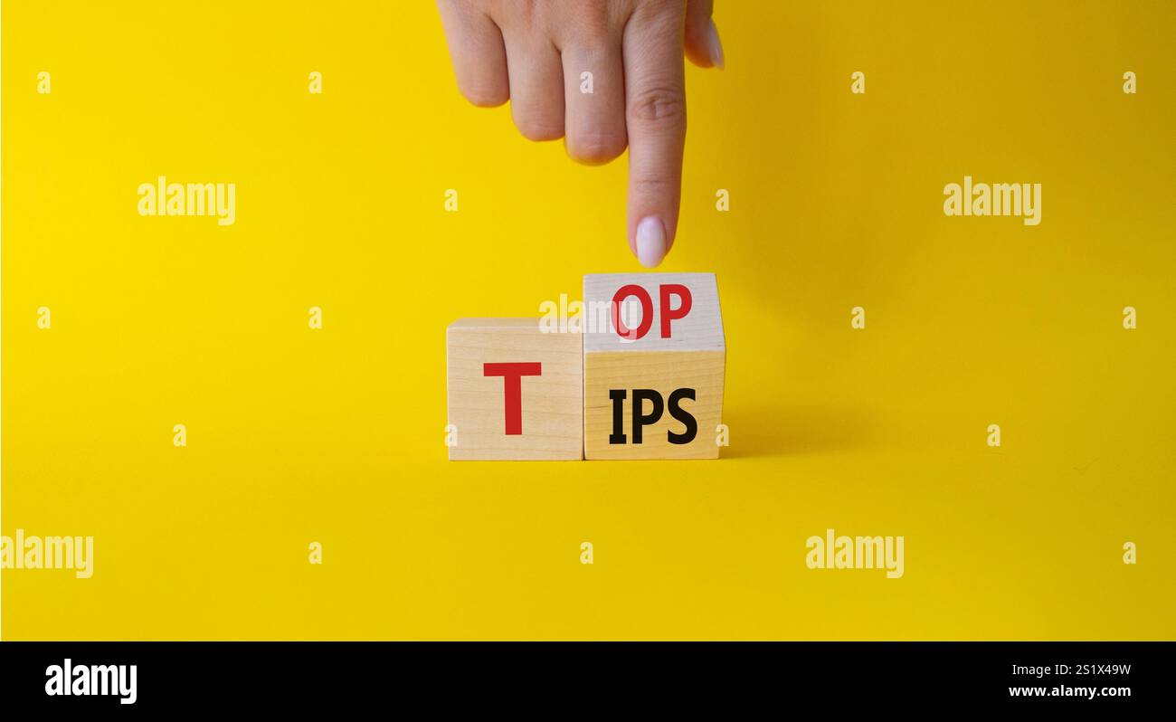 Top Tips symbol. Businessman hand points at turned wooden cubes with ...