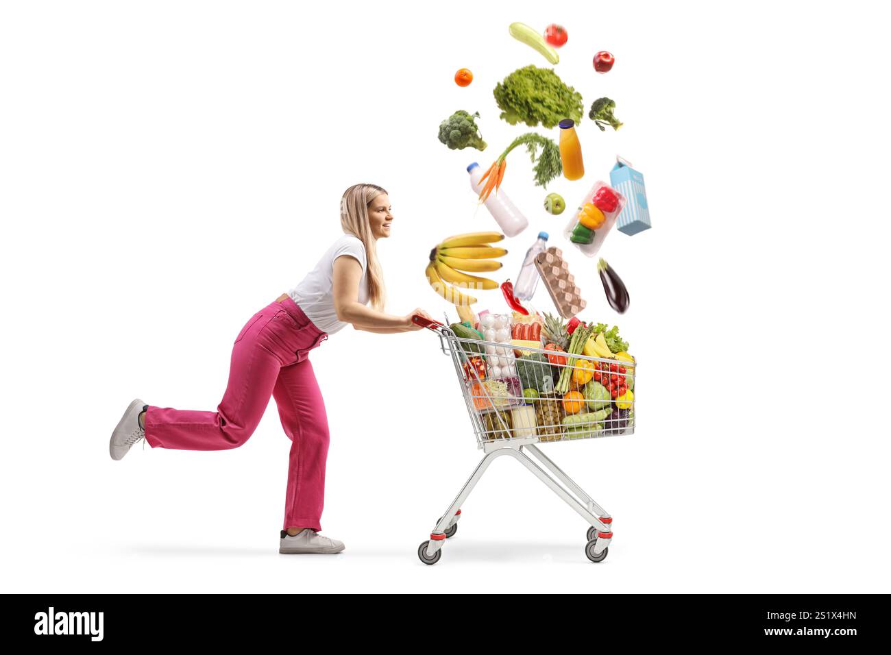 Full length profile shot of a young female running with falling food in ...