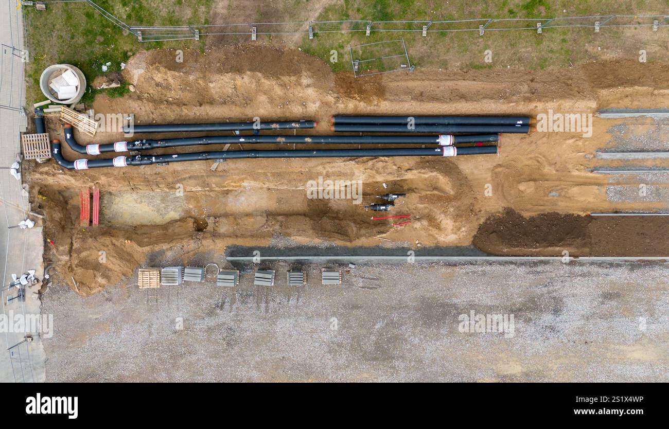 Aerial view of a construction site with multiple black pipes laid in ...