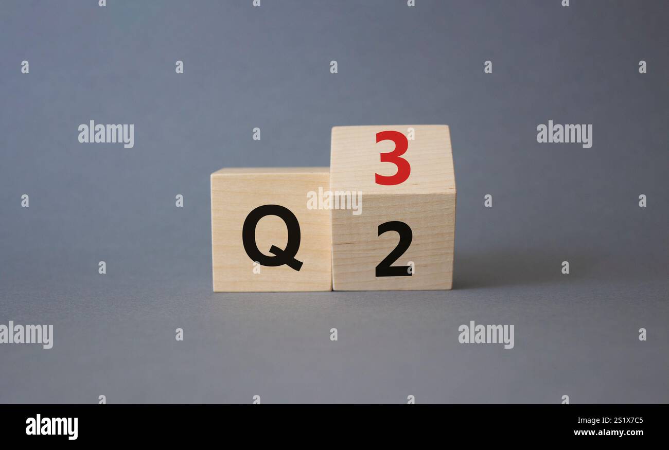 From 2nd Quarter to 3rd symbol. Turned wooden cube with words 2nd Quarter and 3rd Quarter ...
