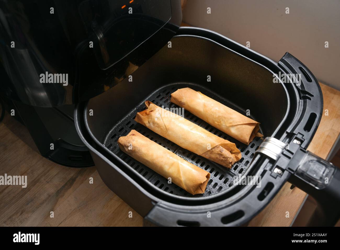 Crispy baked stuffed filo pastry rolls or spring rolls in a hot air ...