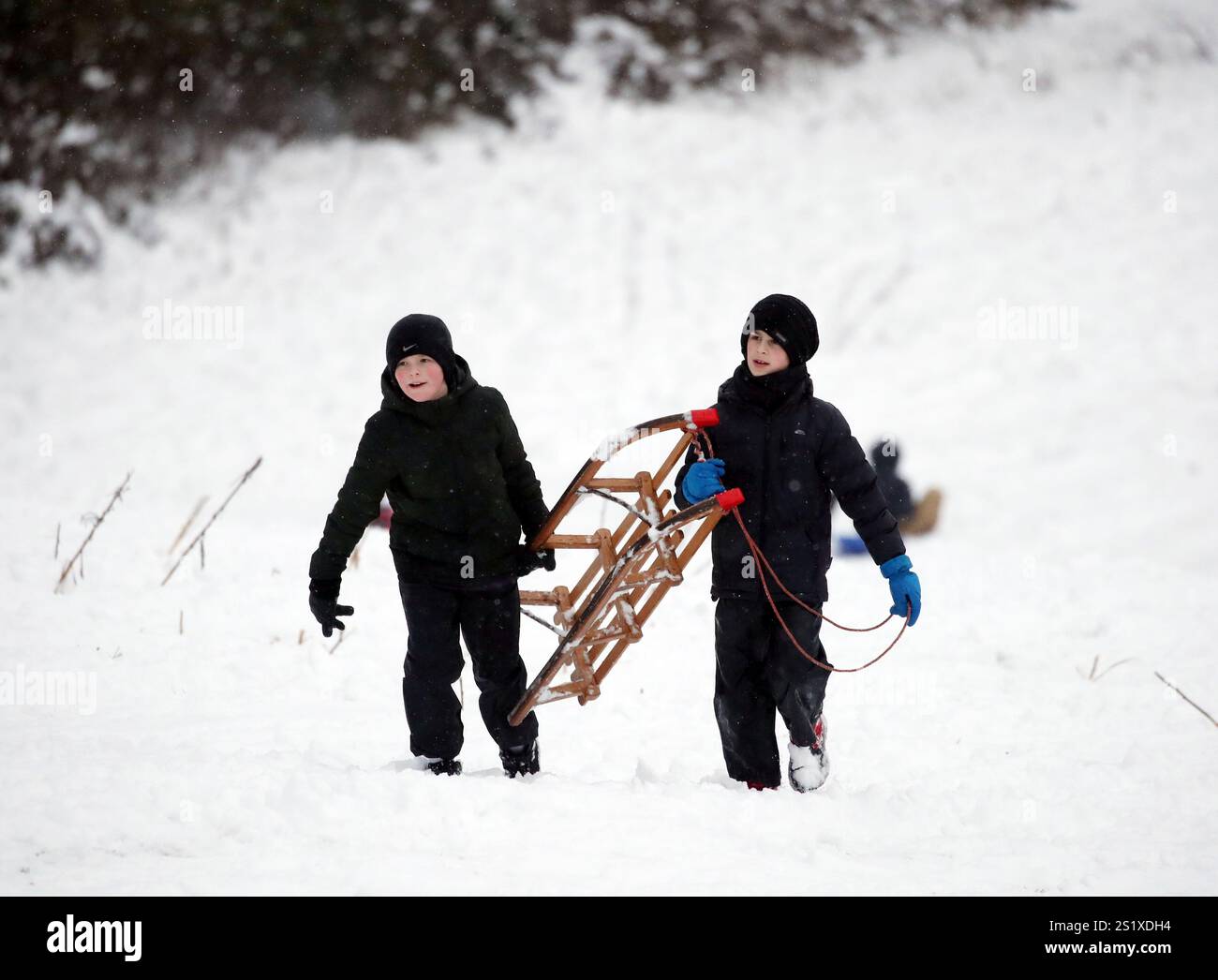 Boys are seen with a sledge on a hill with Durham Cathedral which is ...