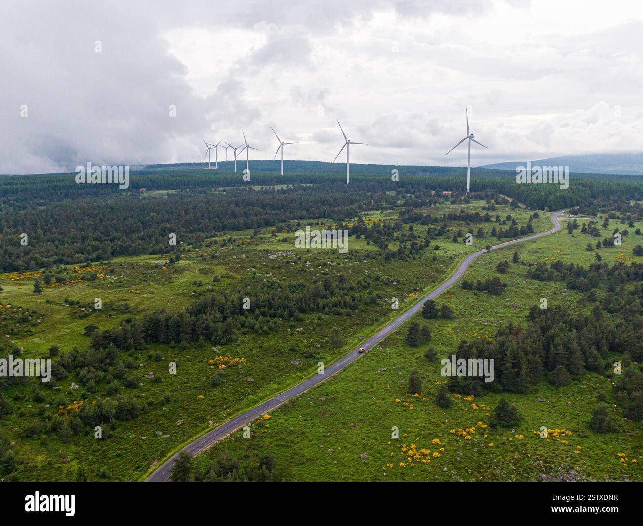 Aerial view of a row of wind turbines generating green energy on a ...