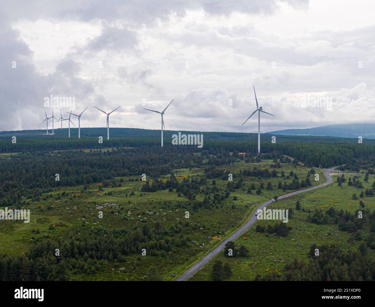 Aerial view of a row of wind turbines generating green energy on a ...