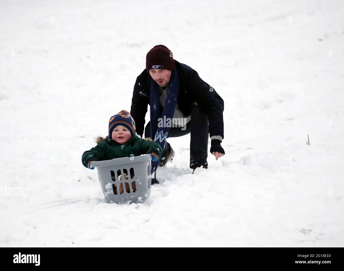 A man is seen with his son as they sledge on a hill with Durham ...