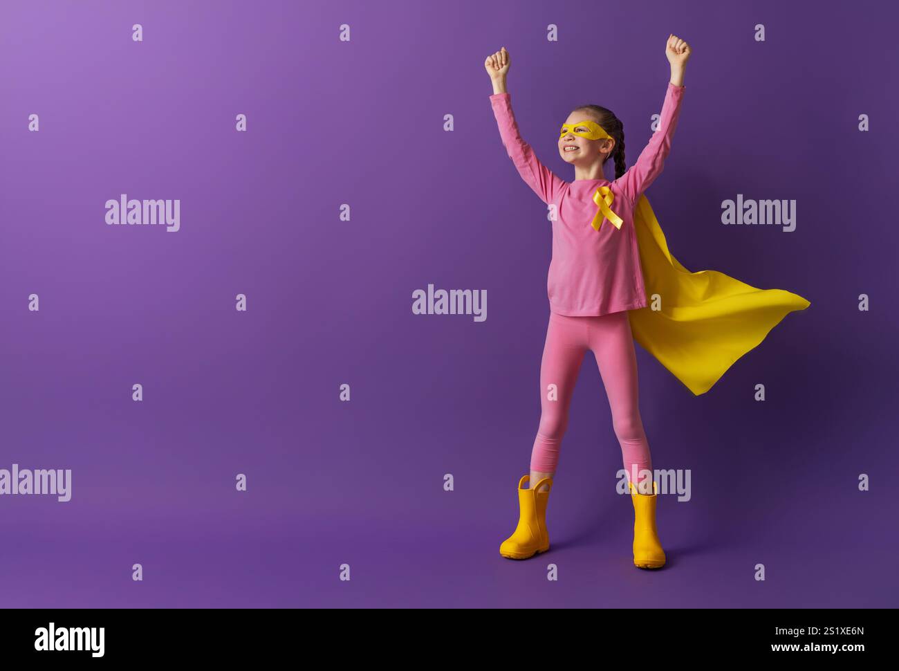 World Childhood cancer Day. Girl in superhero costume with golden ...