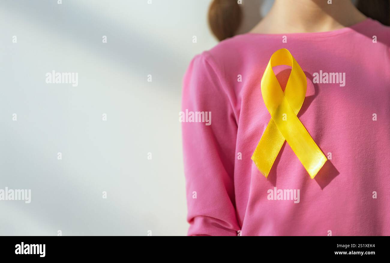 World Childhood cancer Day. Kid with golden ribbon Stock Photo - Alamy