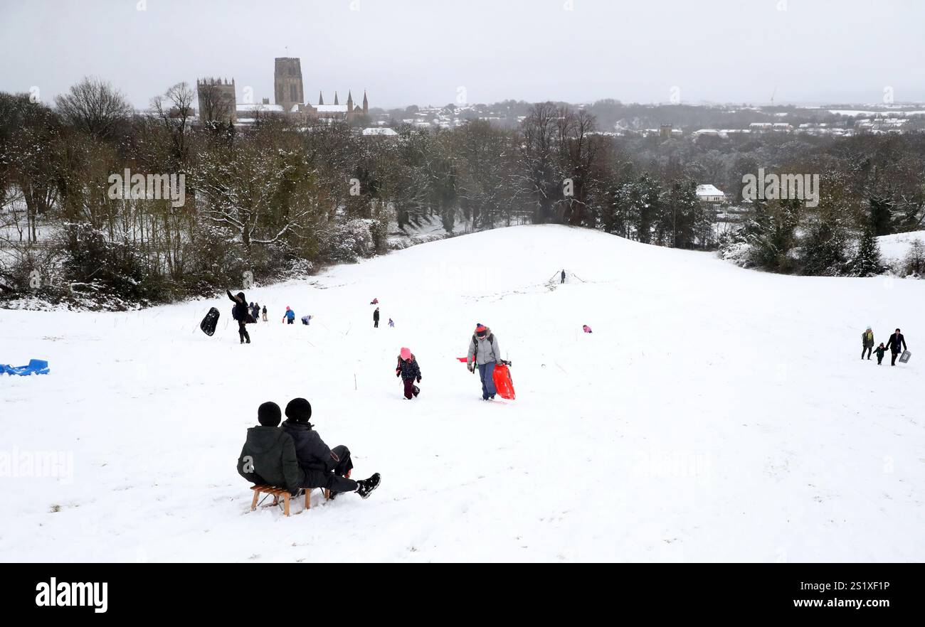 Members of the public are seen sledging on a hill with Durham Cathedral ...