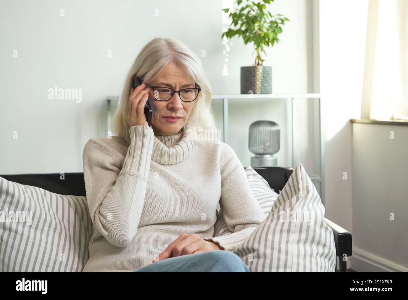 Senior woman on a phone call looking distressed about a potential scam ...