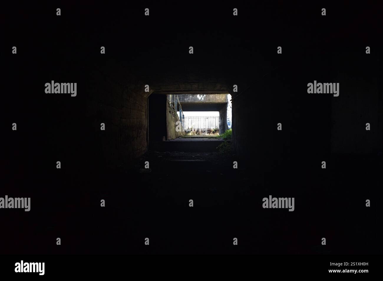 Dirt low passage in the shade under a concrete bridge with a lake at ...