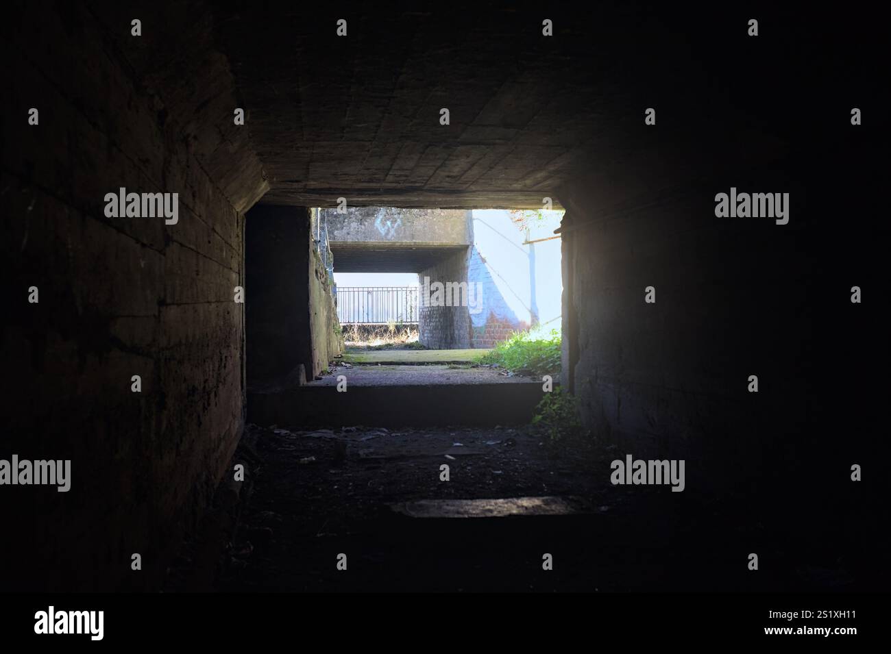 Dirt low passage in the shade under a concrete bridge with a lake at ...