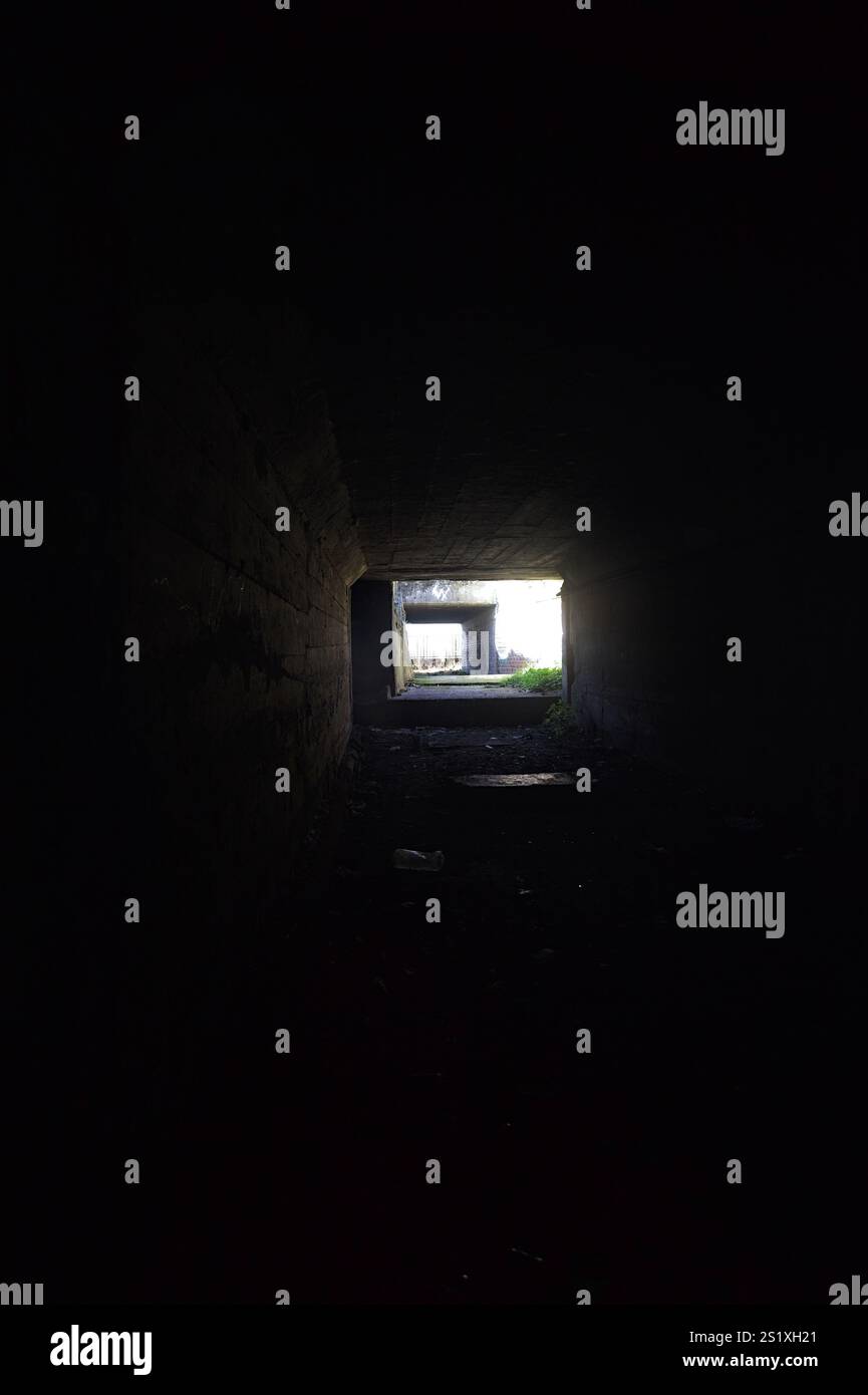 Dirt low passage in the shade under a concrete bridge with a lake at ...