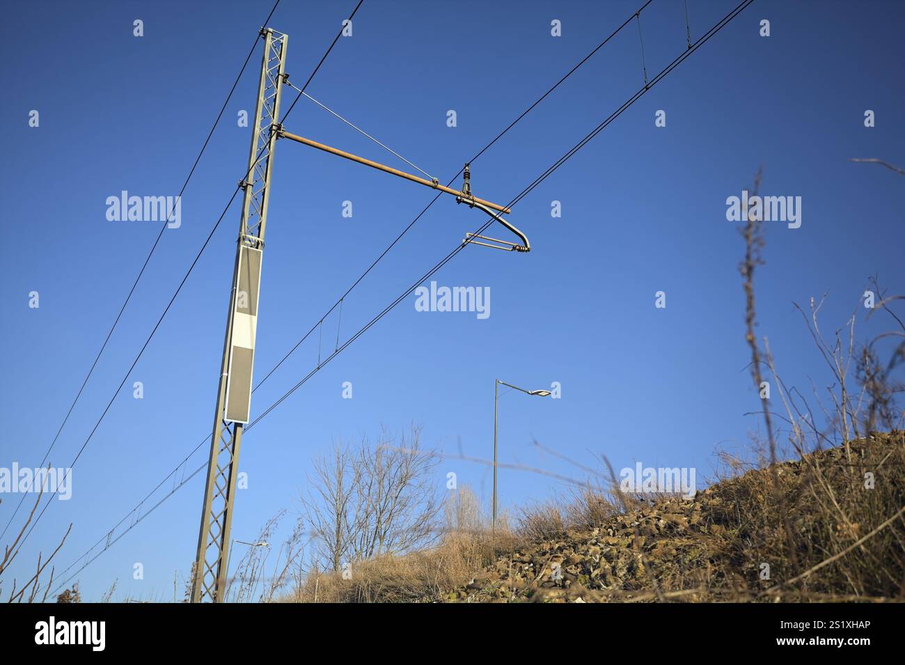 Trellis with a overhead powerline on a railroad over an embankment with ...