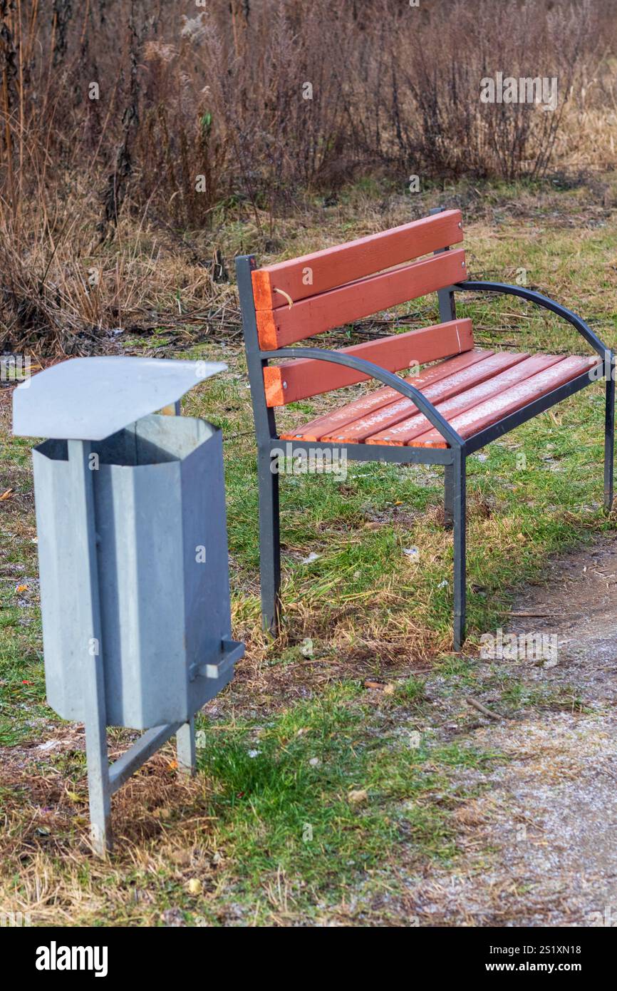Shot of the trash bin by the bench in the park Stock Photo - Alamy
