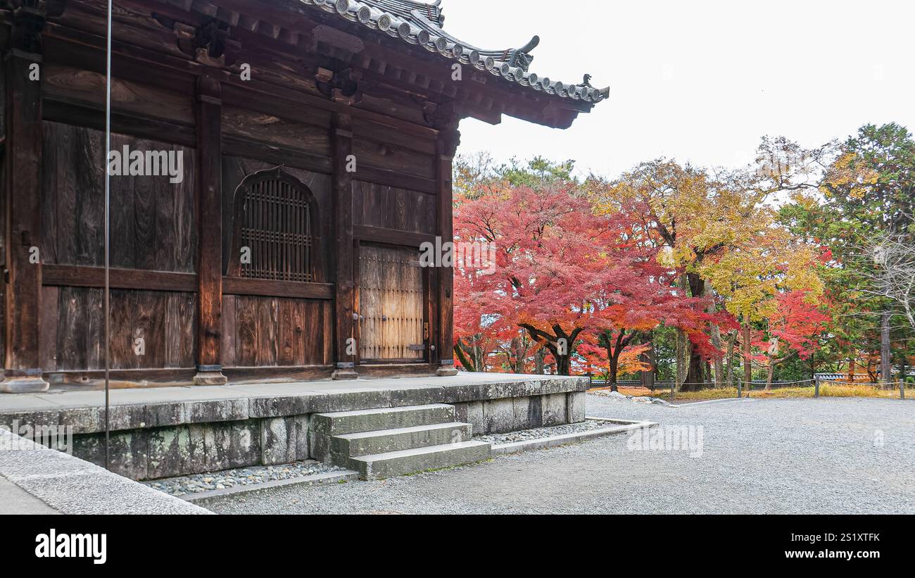A traditional wooden temple building at Nanzen-ji with vibrant autumn ...