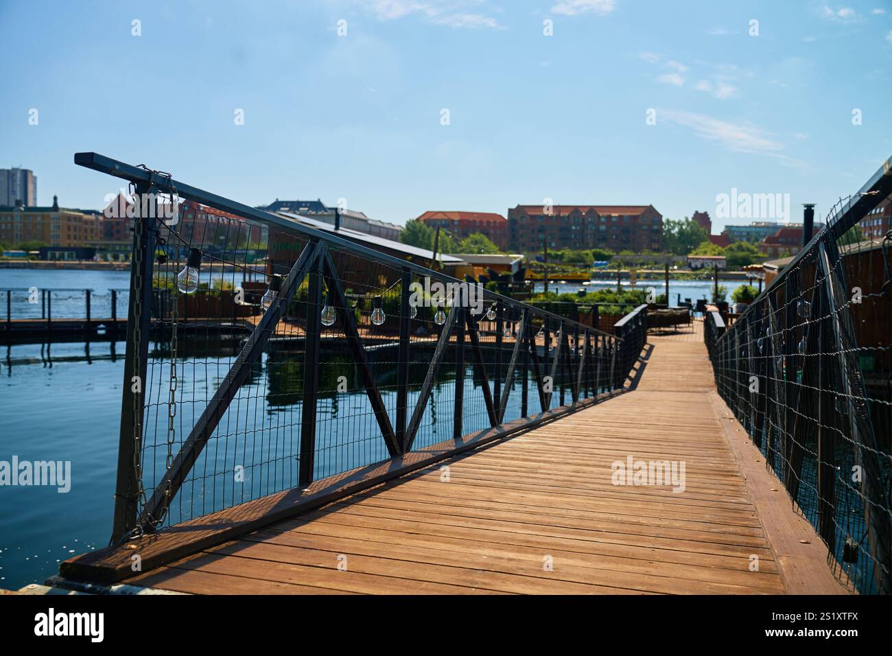 Wooden walkway with railings leading to stylish restaurant on city ...