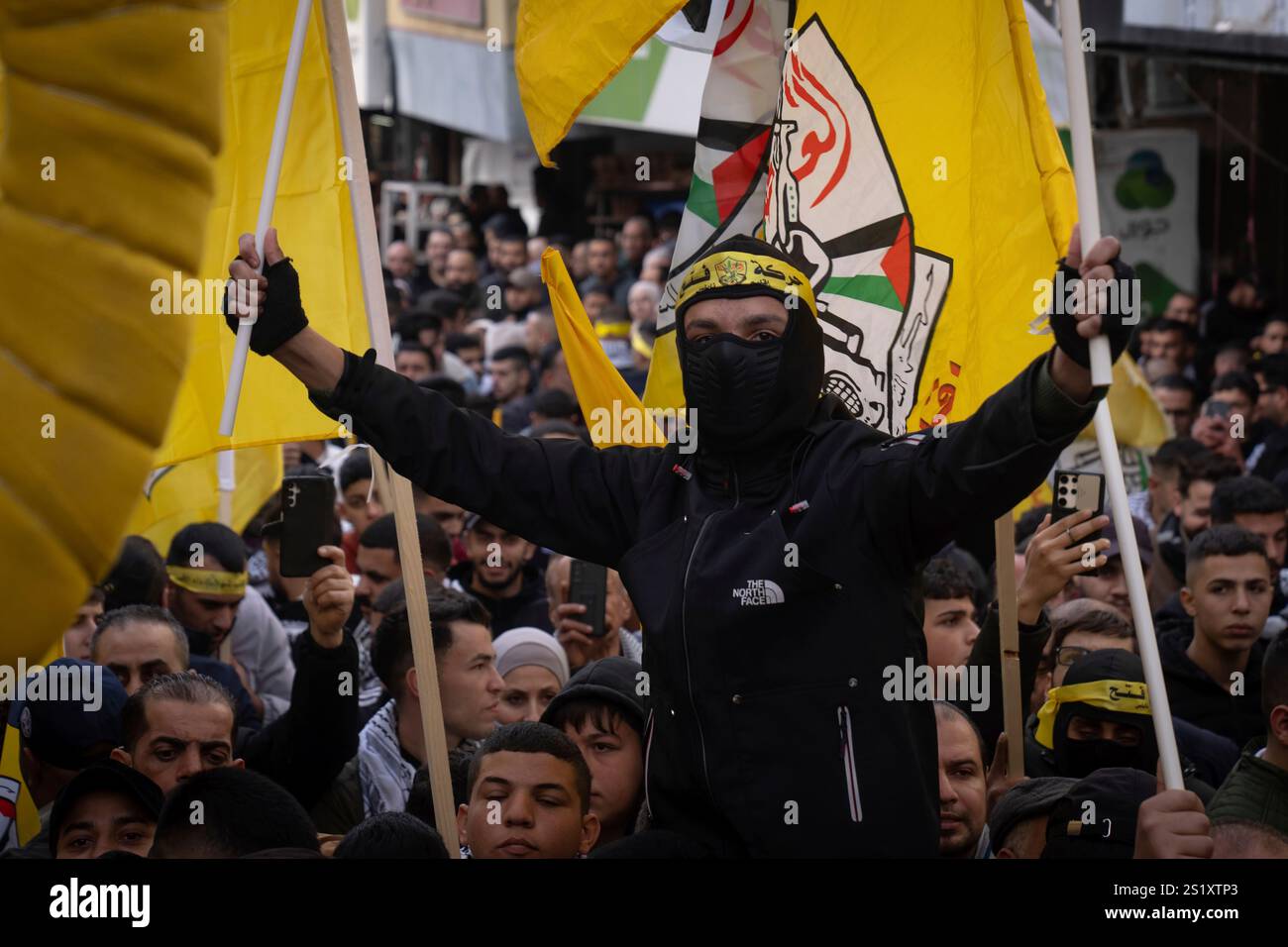 Palestinians hold yellow Fatah flags during the march for the 60th ...