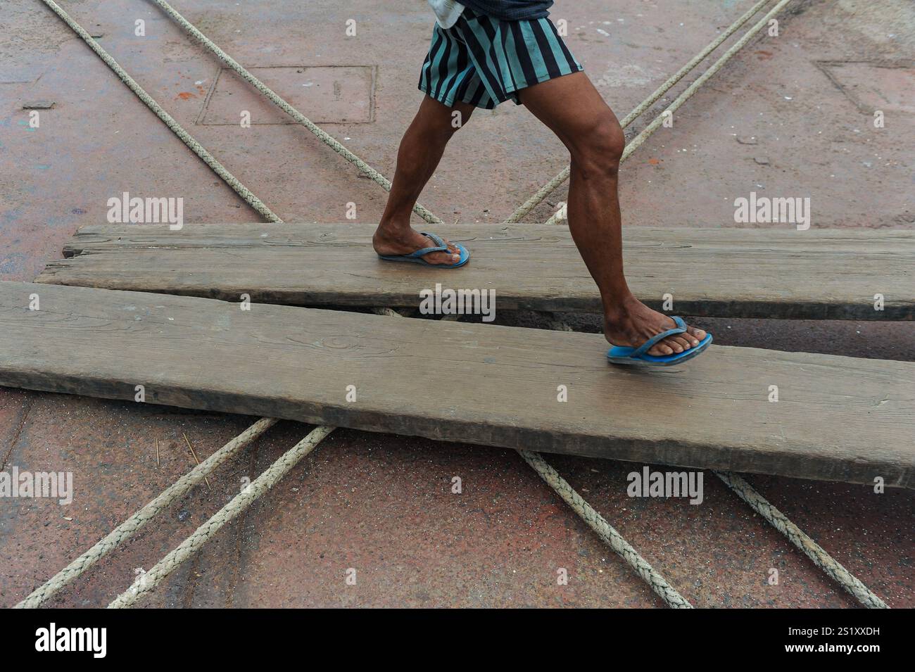 11.11.2015, Yangon, Myanmar, Asia - A man wearing flip-flops walks over ...