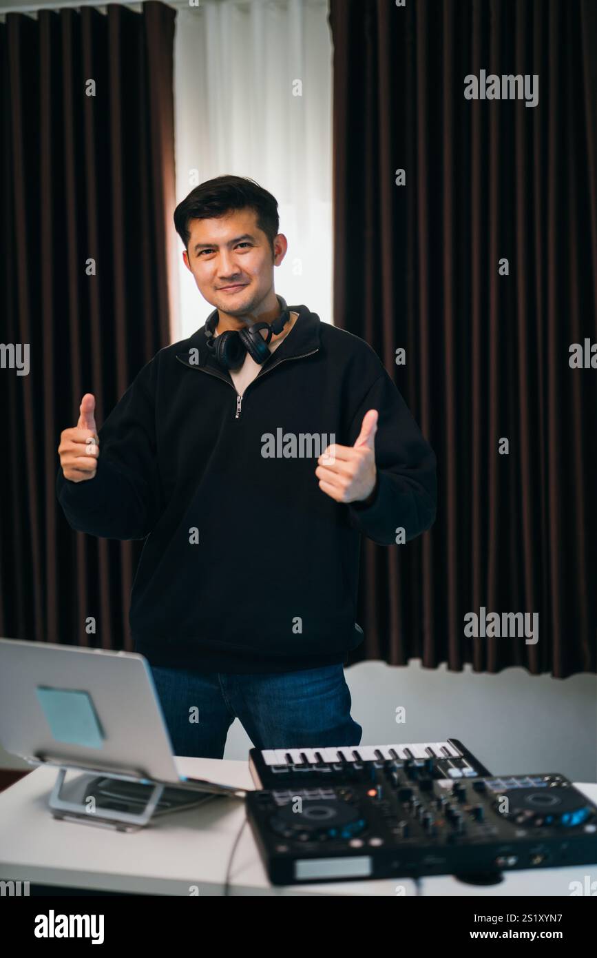 Portrait of Asian dj at a house party spinning tracks on a compact ...