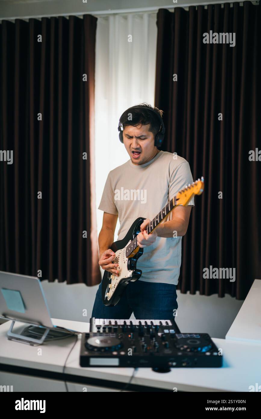 Asian male blending guitar melodies with electronic beats, surrounded ...