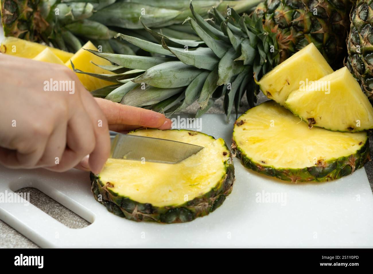 Hands cutting fresh pineapple fruit into pieces Stock Photo - Alamy