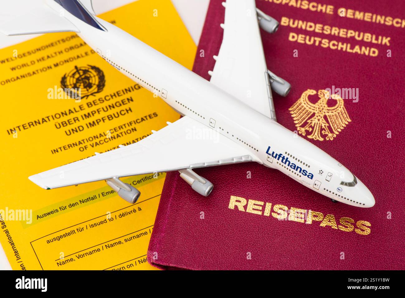 Flugreise mit Reisepass und Impfbuch Ein Modellflugzeug der Lufthansa ...