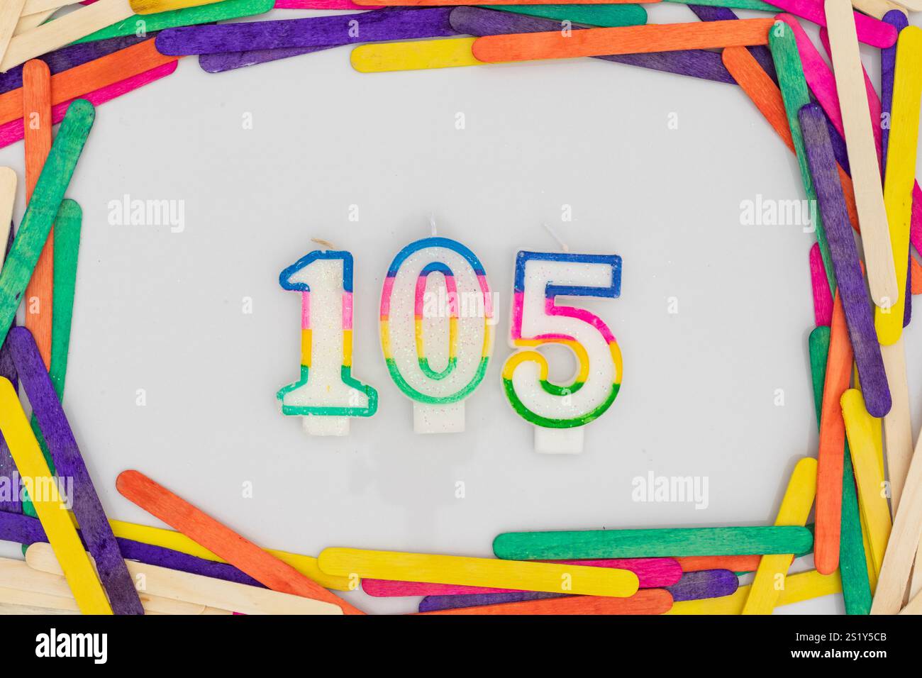 Candles in shape of the number 105 in popsicle colorful sticks frame ...