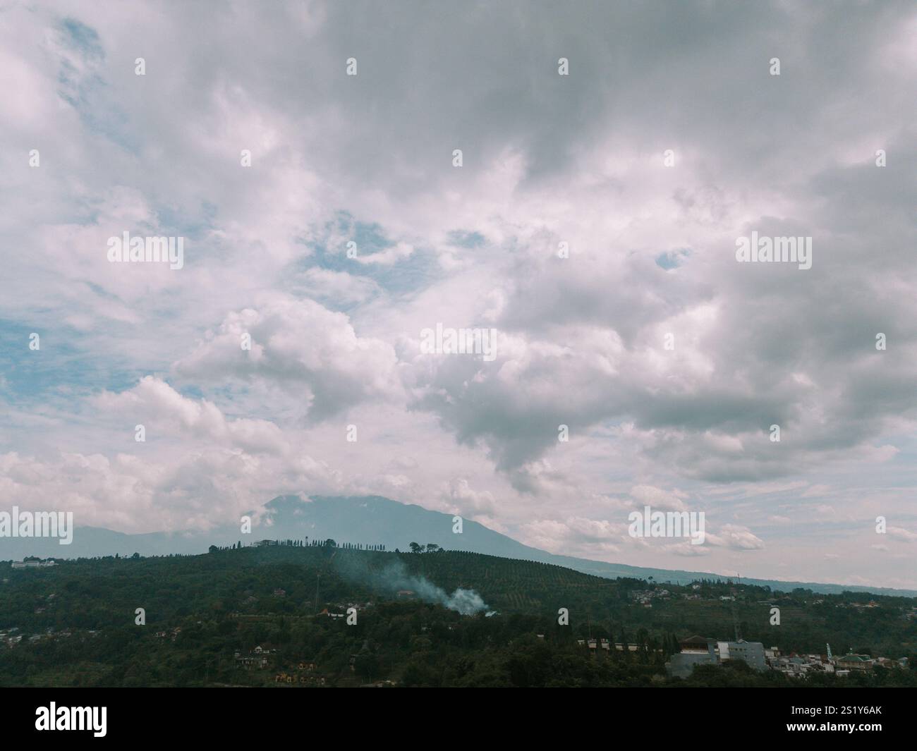 Clouds hovering over a mountain in a village with an overcast sky ...
