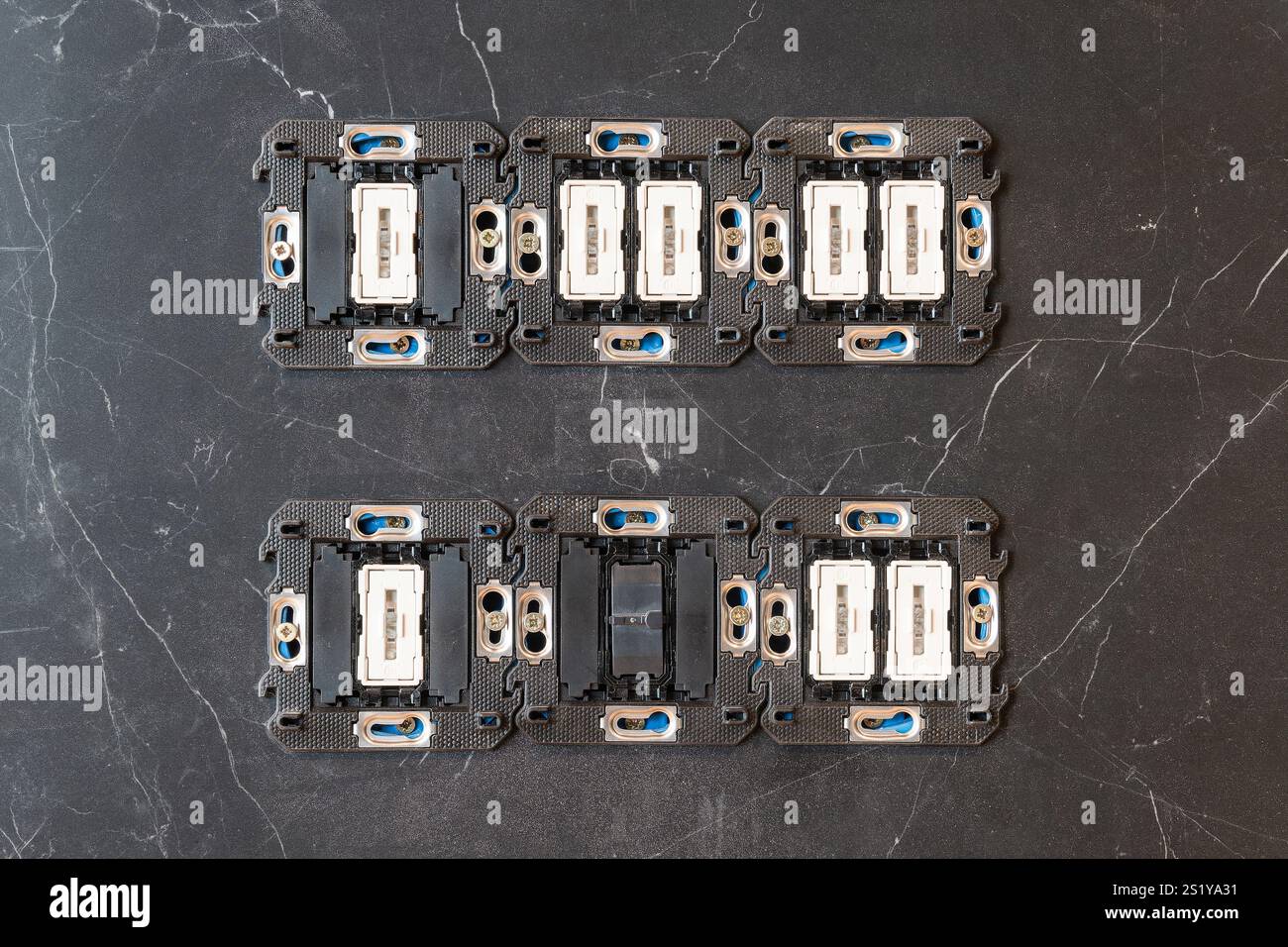 Electrical switch mechanisms mounted in two rows on the porcelain tile ...