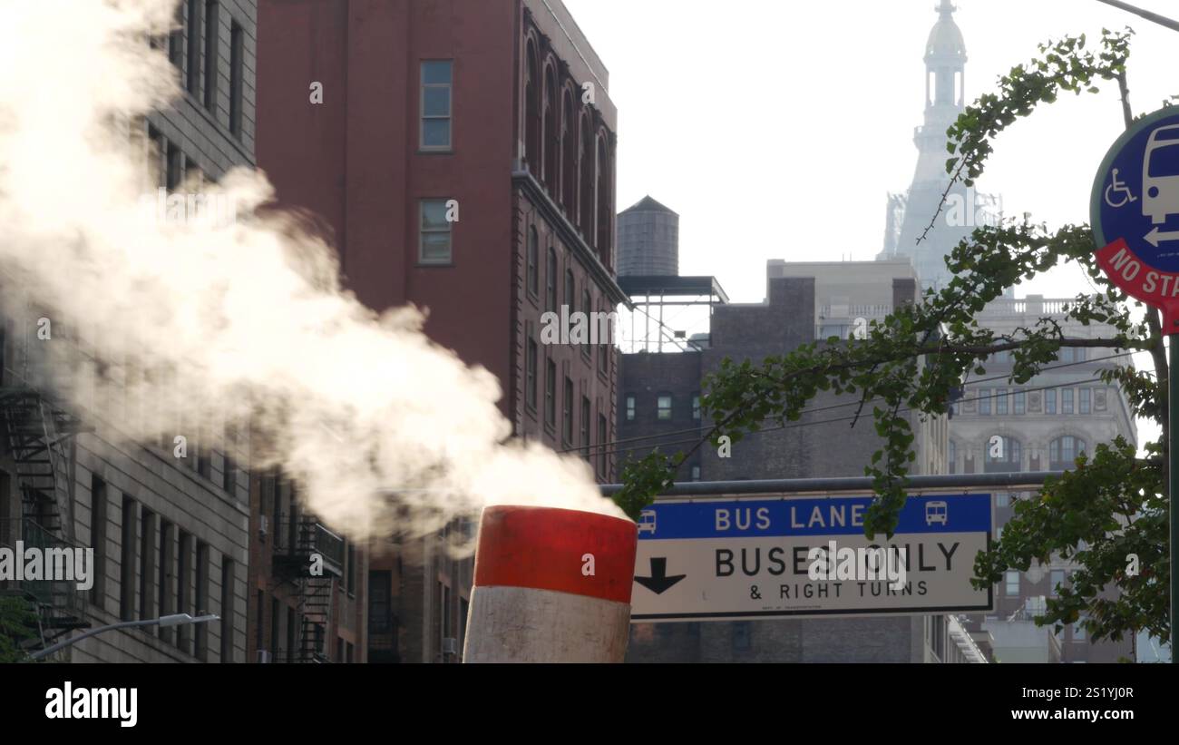 Steam vapor vented on New York City street, orange vapour tube stack ...