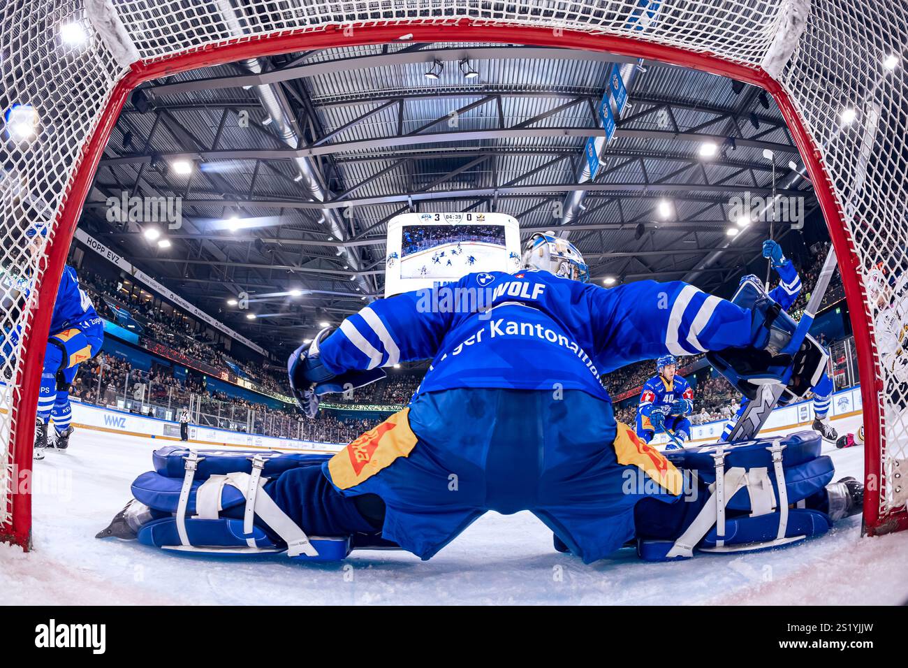 Goalkeeper Tim Wolf #1 (EV Zug) stretches for the puck from the NetCam ...